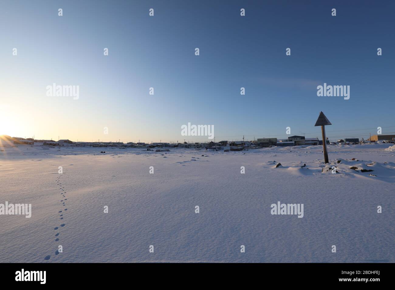 Isolated arctic landscape with Inuit community in the background and ...