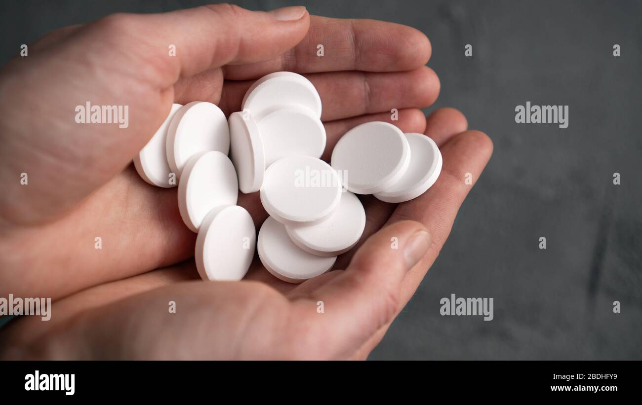 Hand holding pills to treat the ache. Dosage for patients or how to ...