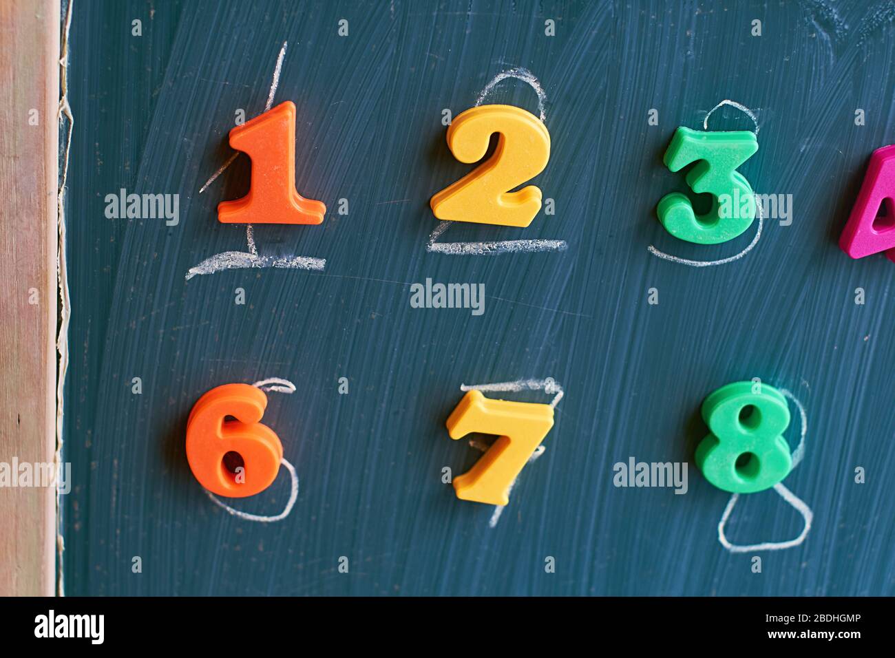 Learning numbers on a blackboard with colorful magnets and handwriting ...