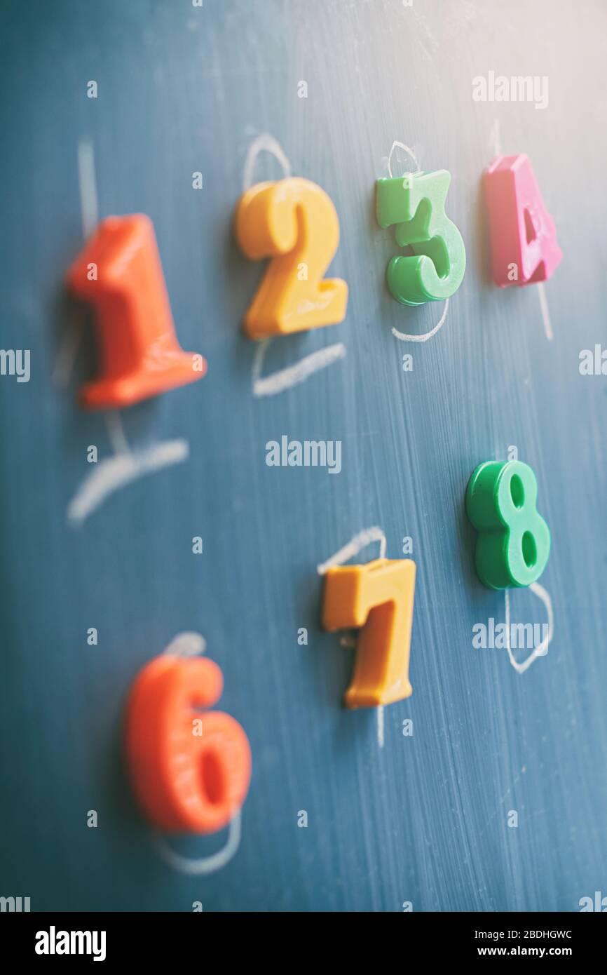 Learning numbers on a blackboard with colorful magnets and handwriting ...