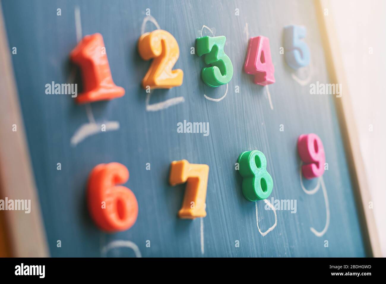 Learning numbers on a blackboard with colorful magnets and handwriting ...