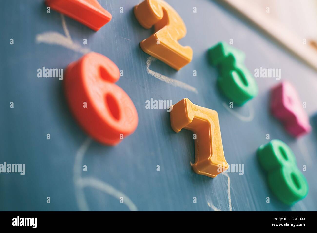 Learning numbers on a blackboard with colorful magnets and handwriting ...