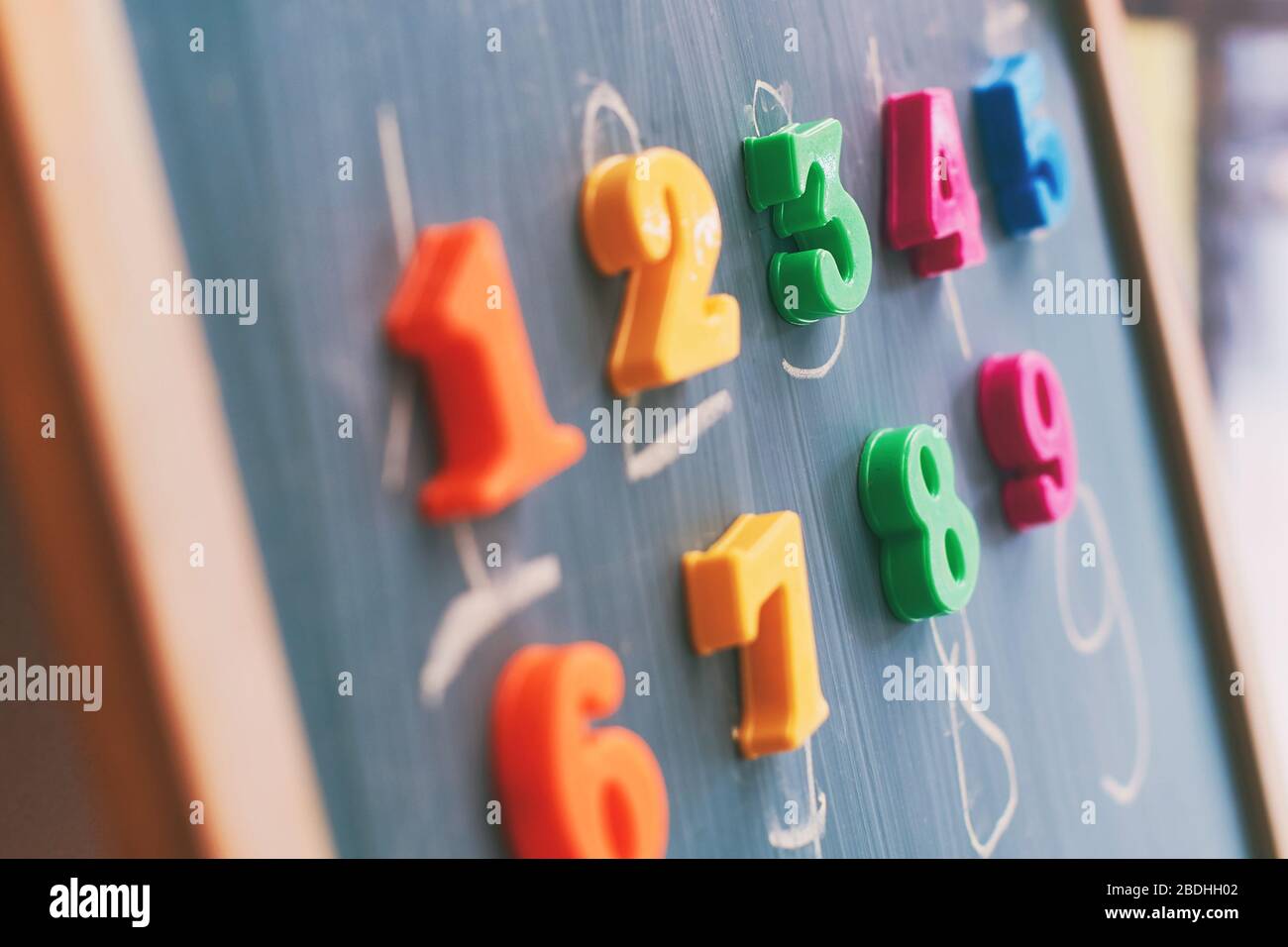 Learning numbers on a blackboard with colorful magnets and handwriting ...