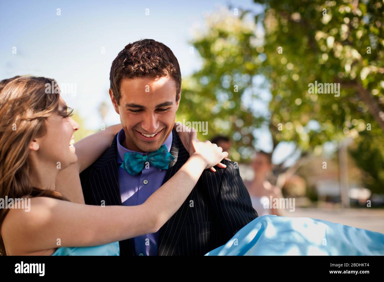 Teenage boy caring his prom date laughing Stock Photo - Alamy