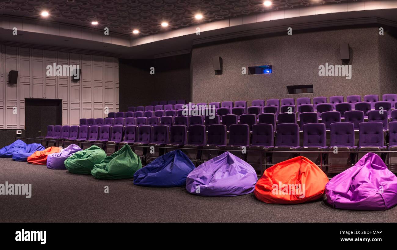 Empty comfortable red seats with numbers in cinema General plan of pink ...