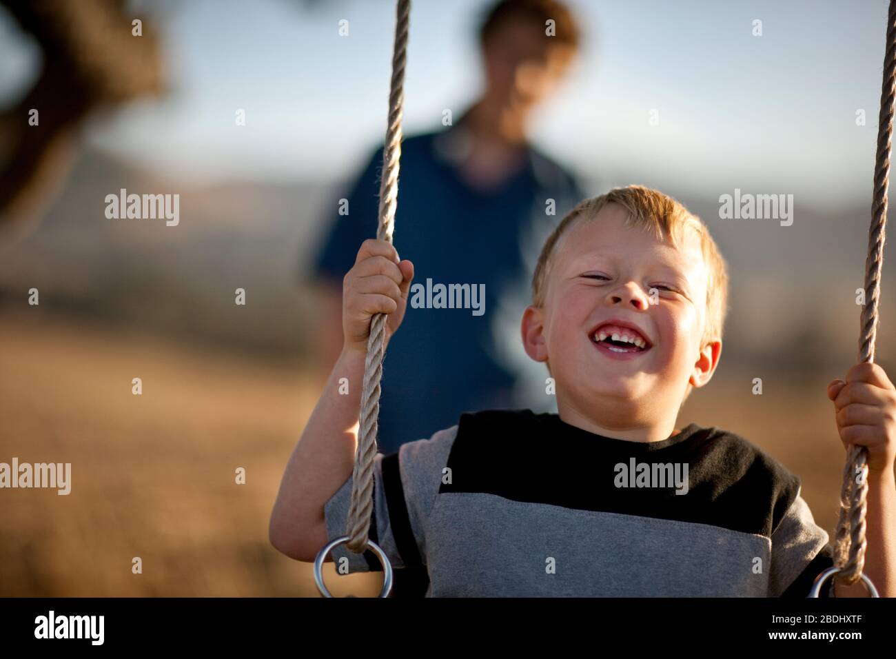 Two kids playing on swing hi-res stock photography and images - Alamy
