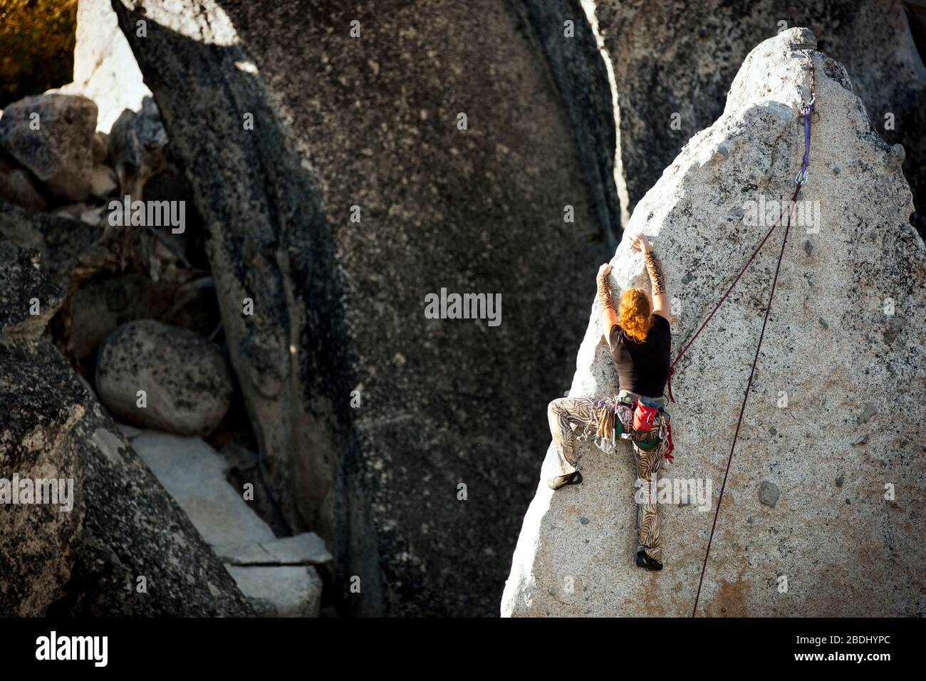 Woman climbing large rock-face Stock Photo - Alamy