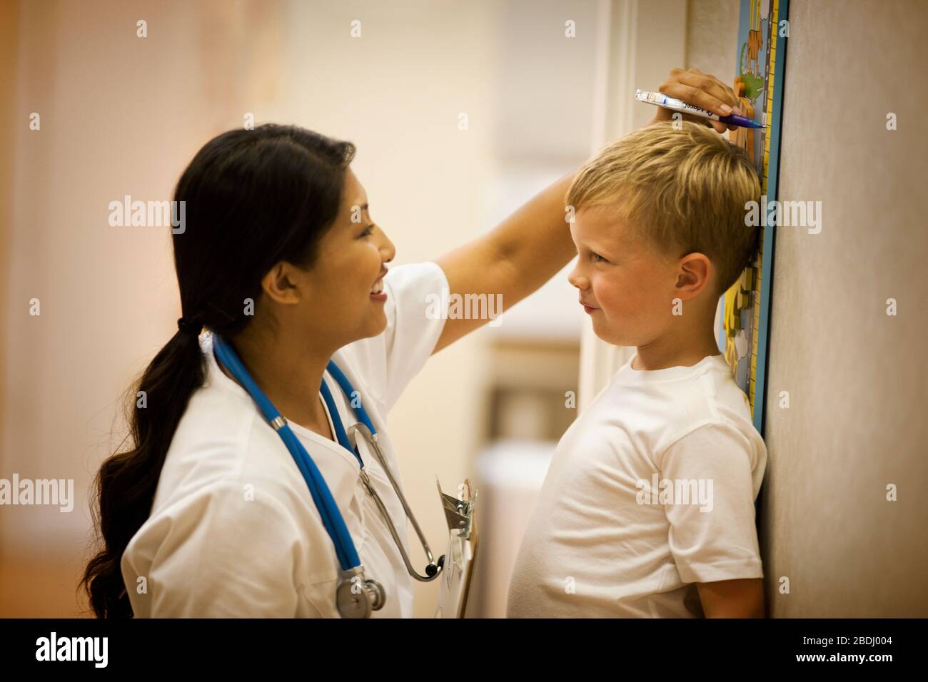 Little boy having his height measured by the nurse Stock Photo - Alamy
