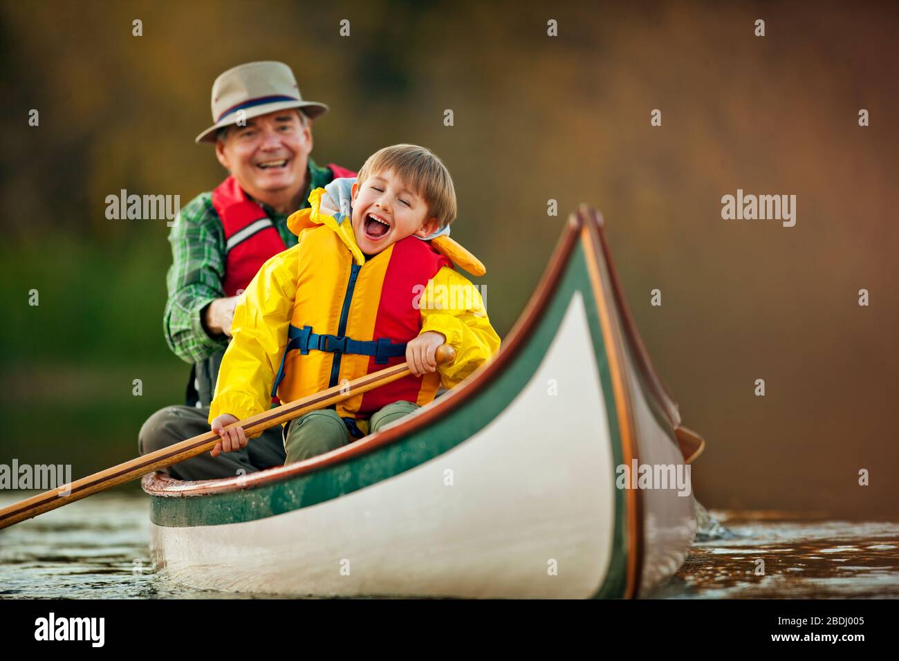 Happy grandfather and young grandson canoeing together on a lake Stock ...
