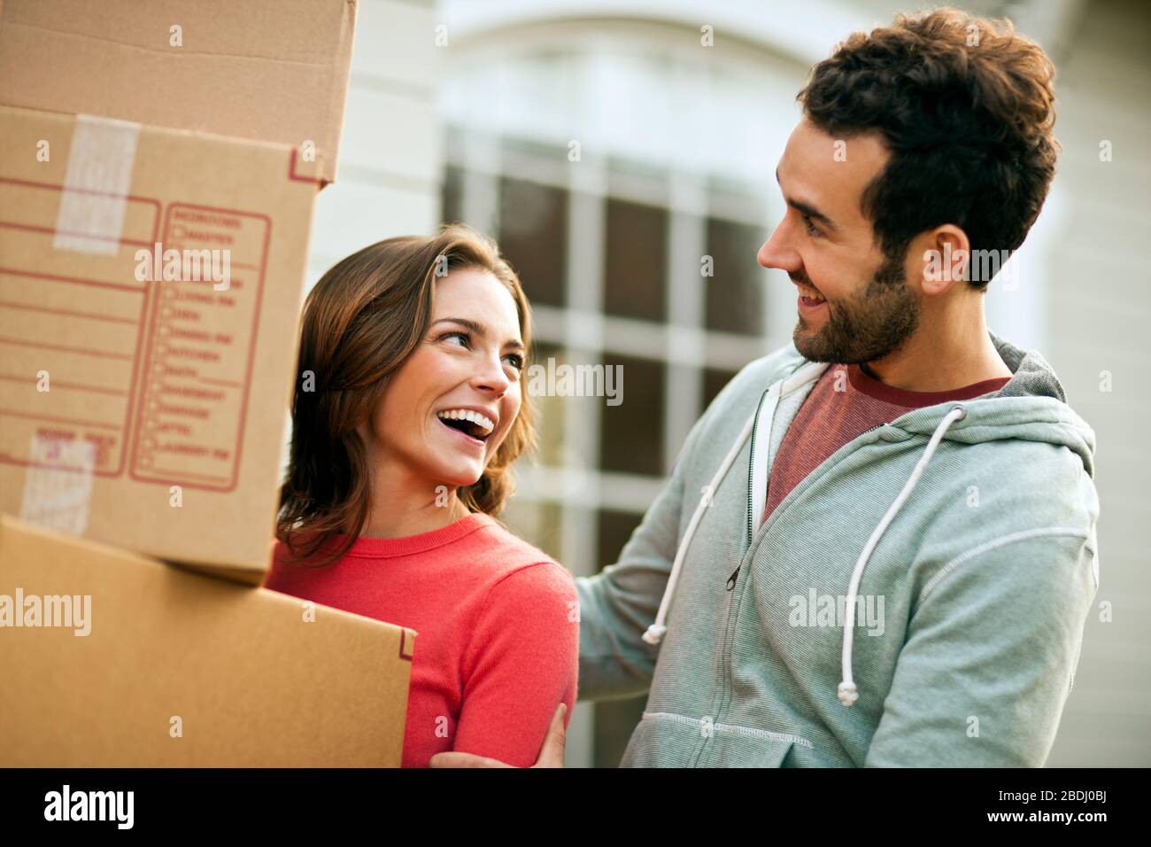Mid-adult couple carry moving boxes Stock Photo - Alamy