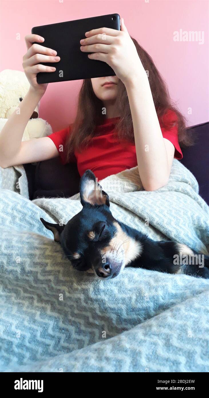 Girl on gray sofa holding hi-res stock photography and images - Alamy