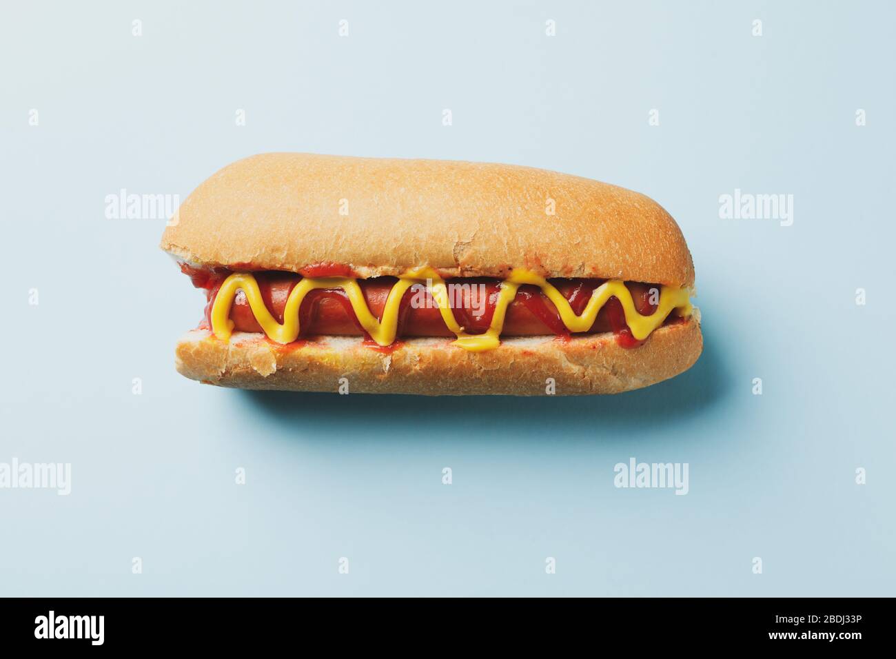 Tasty hot dog with sauces on blue background Stock Photo - Alamy