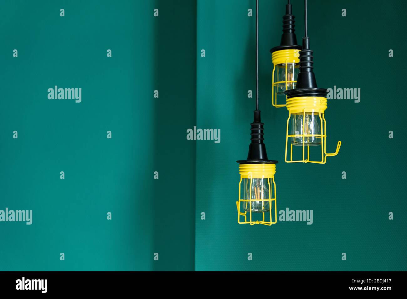 An interior with three yellow work or inspection lamps against a green ...