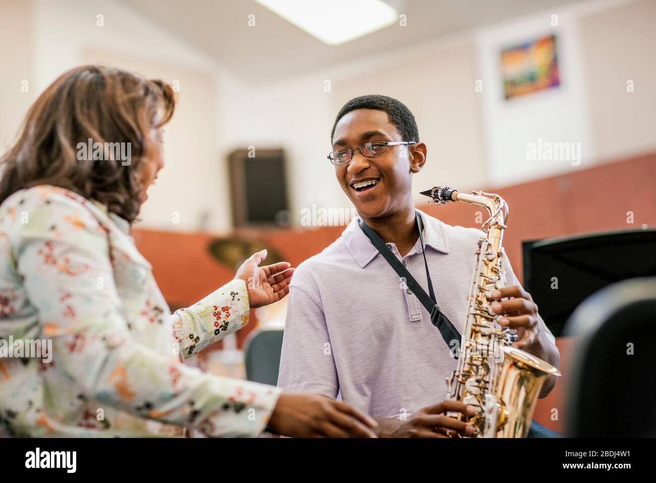 Happy teenage boy in class with his music teacher Stock Photo - Alamy
