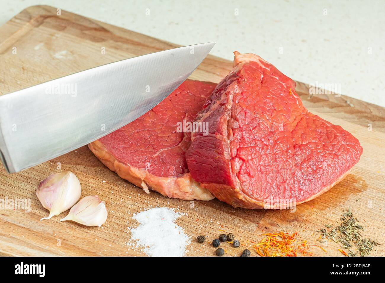 A knife cuts a slice of meat. recipe for meat cooking with saffron ...