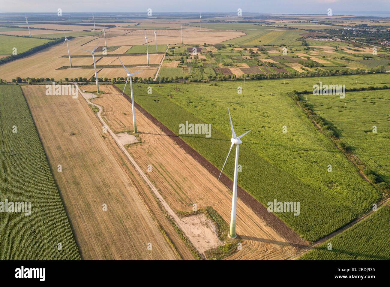 Aerial view of wind turbine generators in field producing clean ...