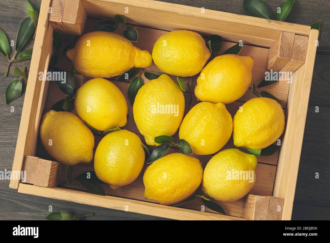 Wooden box of fresh lemons with tree leaves Stock Photo - Alamy
