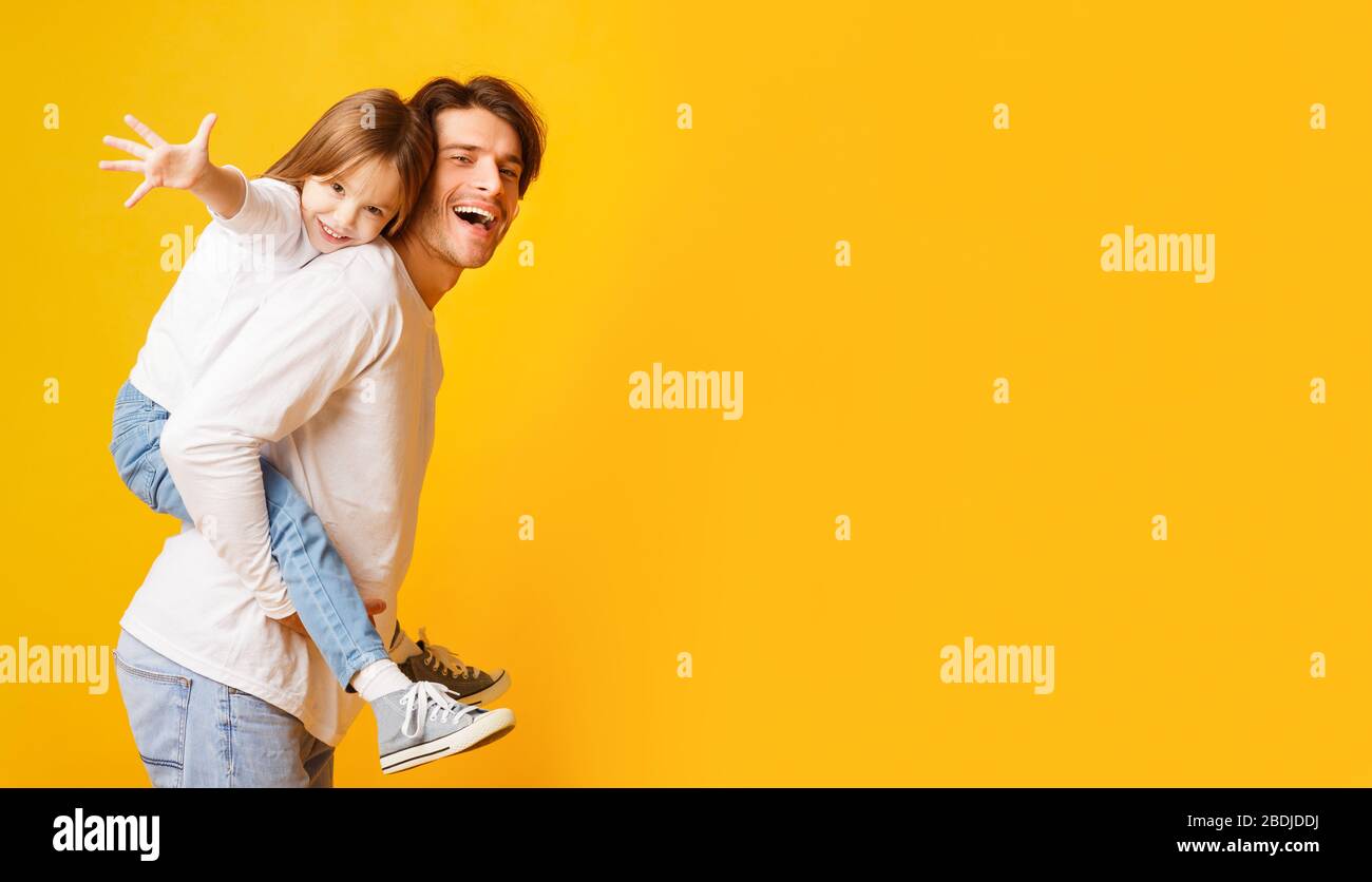 Positive dad holding his happy daughter on his back Stock Photo - Alamy