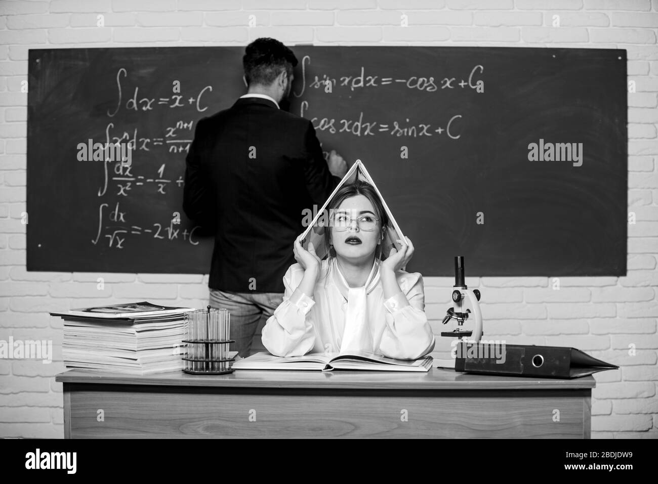 Solving task. Man writing on chalkboard math formulas. Teaching in ...