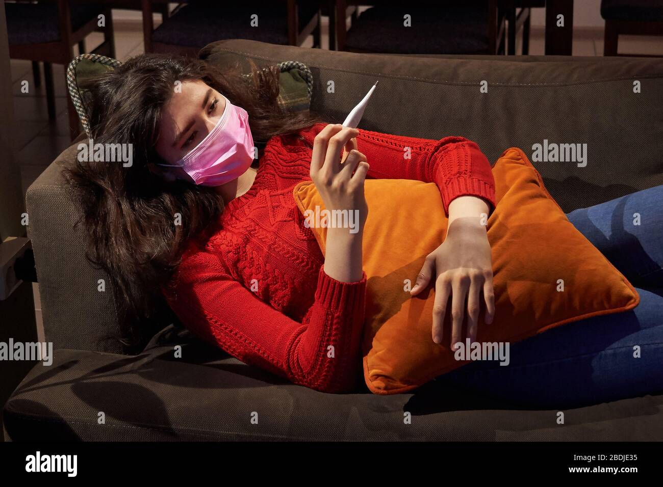 young woman holding thermometer on sofa got fever, caught, sick girl ...