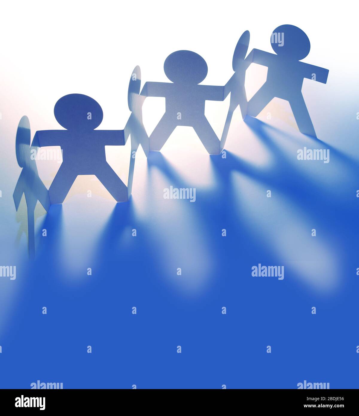 Paper chain team holding hands. Teamwork. Partnership Stock Photo - Alamy