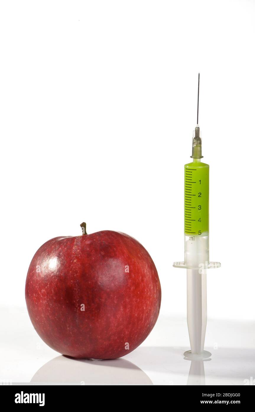 Syringe with green serum and red apple Stock Photo - Alamy