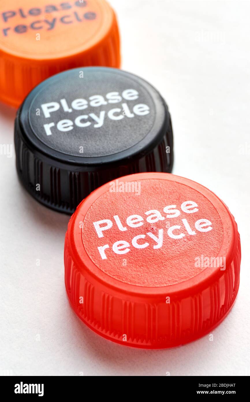Black, orange and red bottle caps with please recycle message against a ...