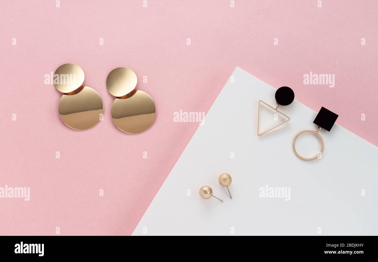 Modern stud earrings on white and pink background Stock Photo - Alamy