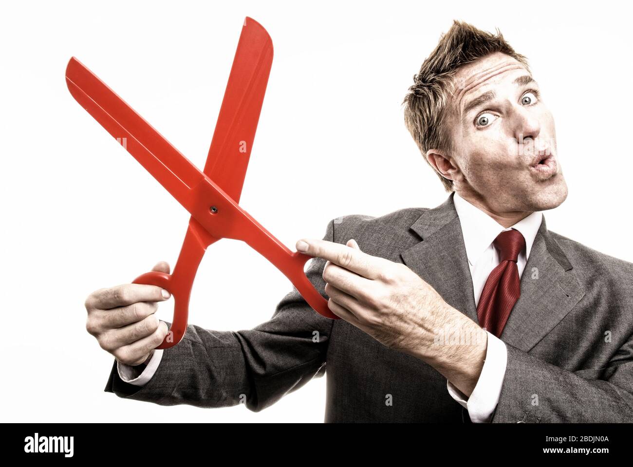 Businessman with pair of oversize bright red scissors making a big cut ...