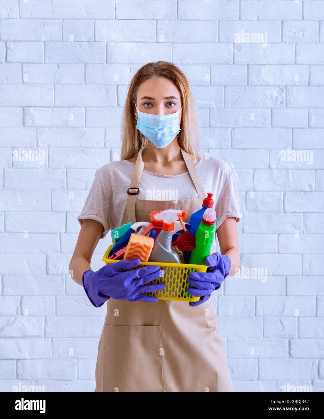 Woman protection house from coronavirus with cleaning supplies Stock ...