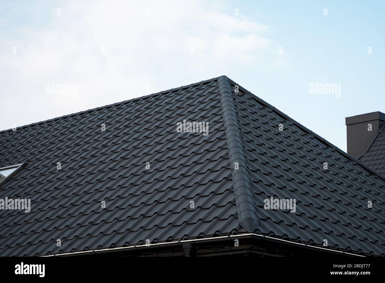 Black metal tile roof. Roof metal sheets. Modern types of roofing ...