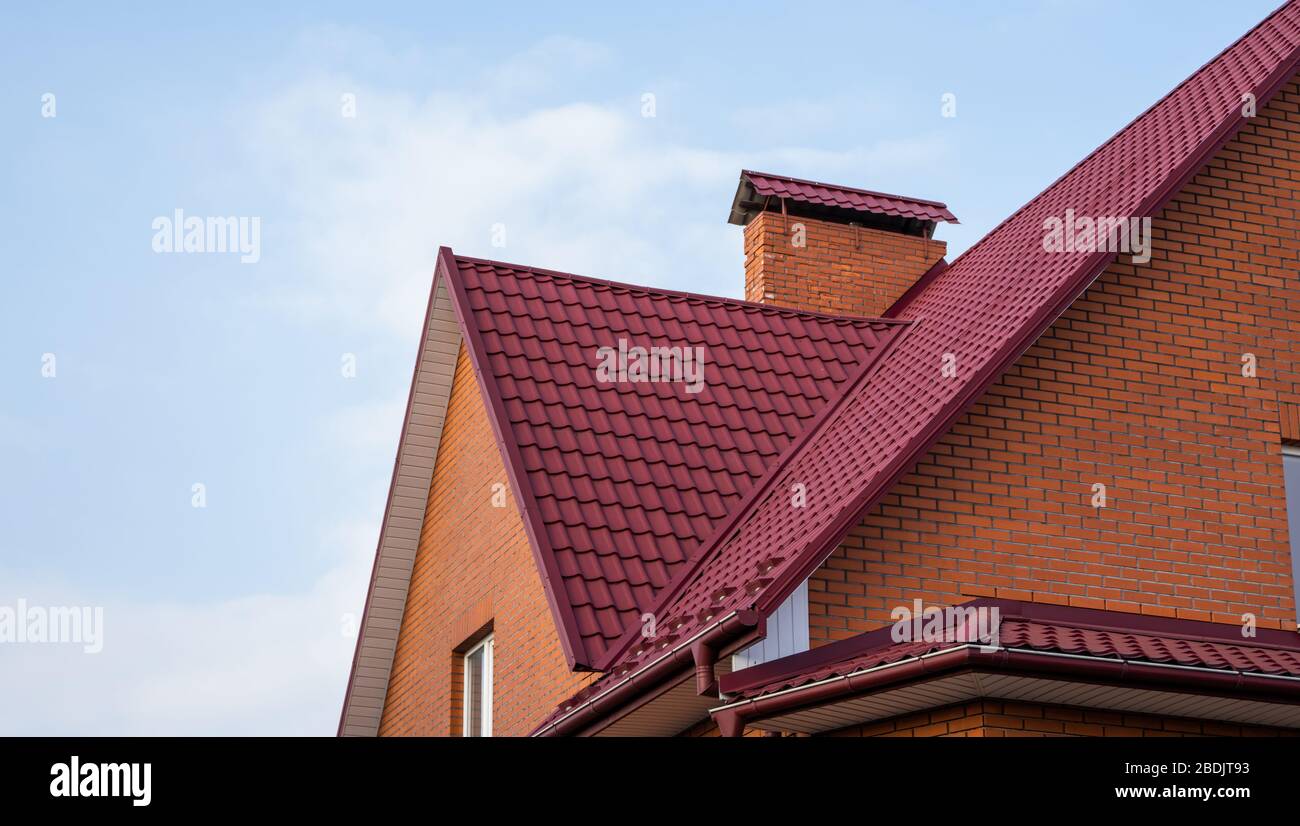 Red metal tile roof. Roof metal sheets. Modern types of roofing ...