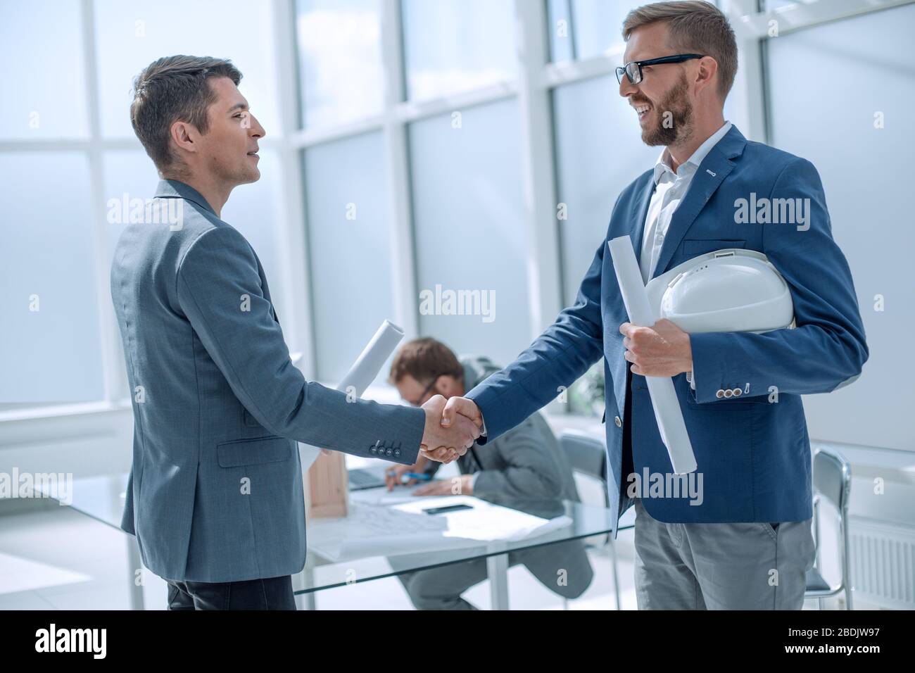 handshake contractor and architect on the background of the office ...