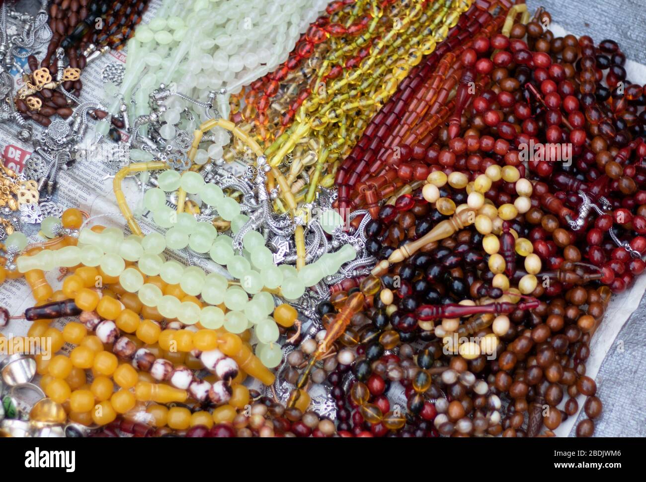 Rosaries in different colors and sizes that have fallen to the ground ...