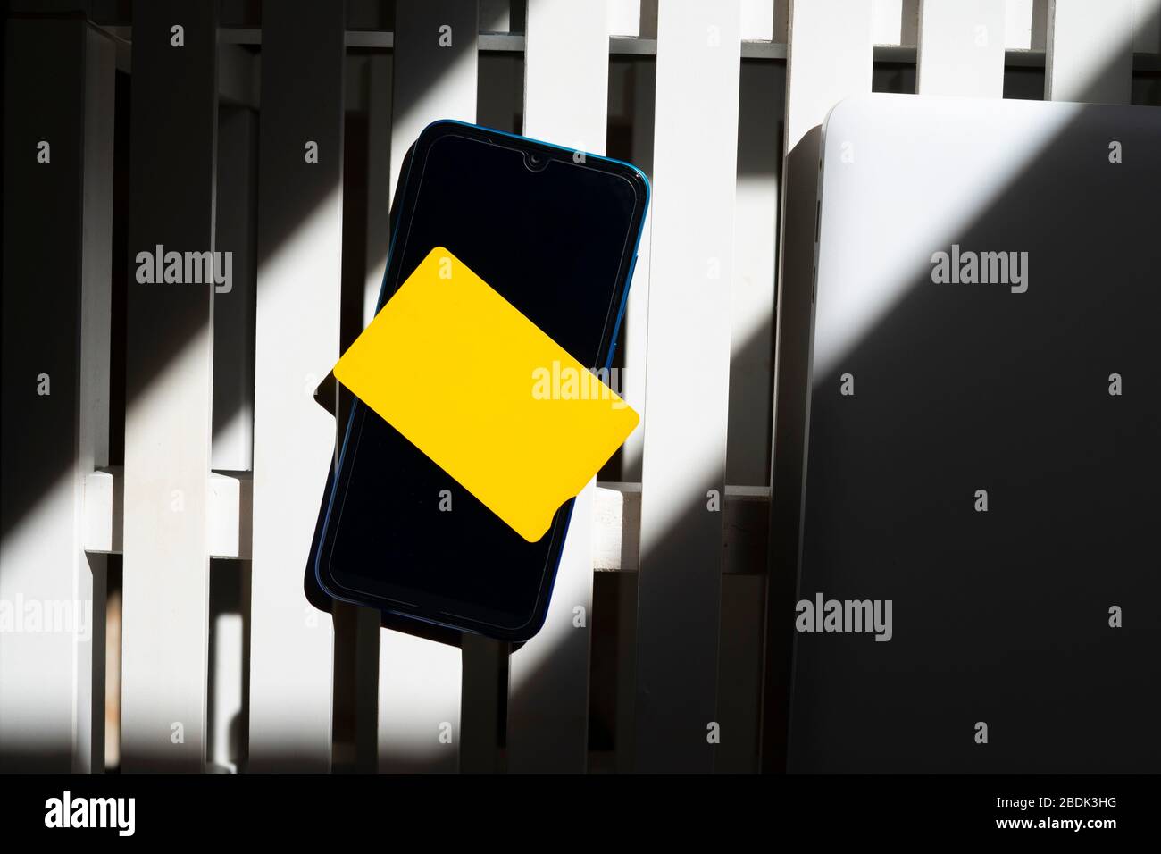 Yellow credit / debit card on top of a mobile. Online shopping concept ...
