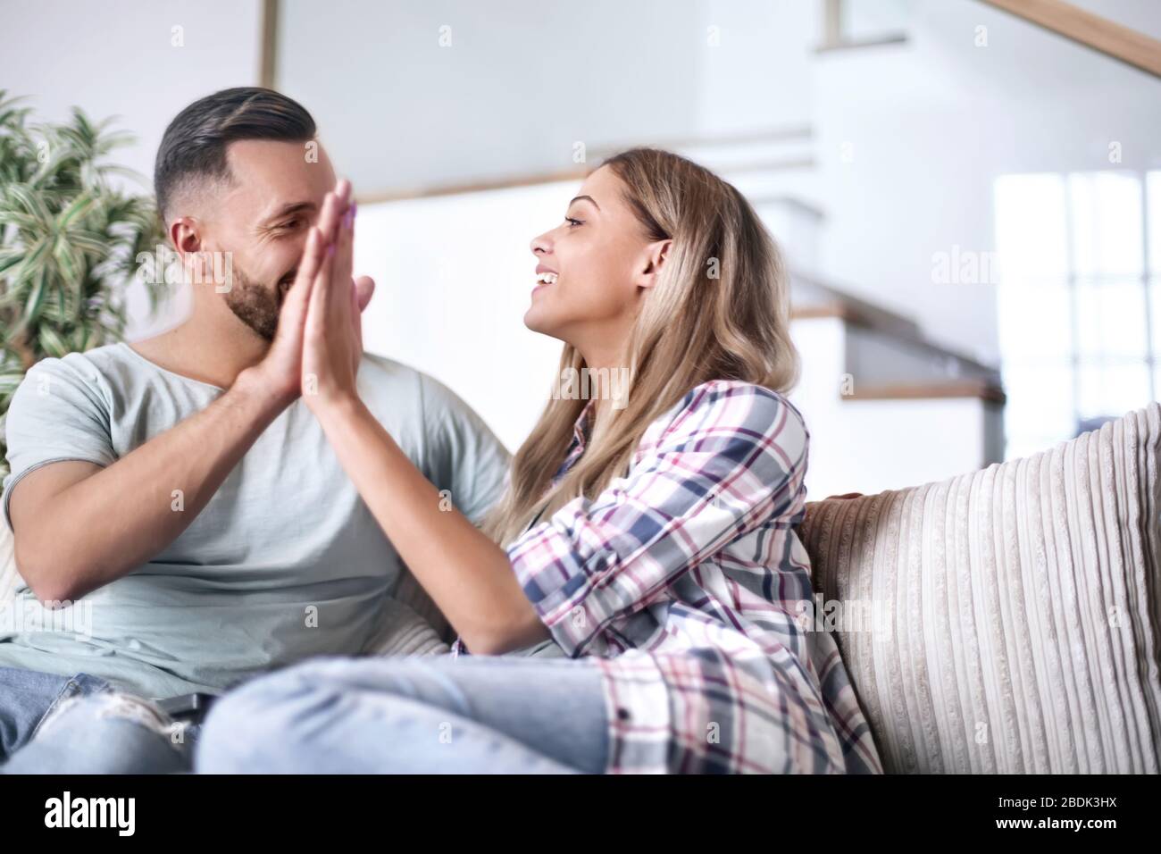 young couple giving each other a high five Stock Photo - Alamy