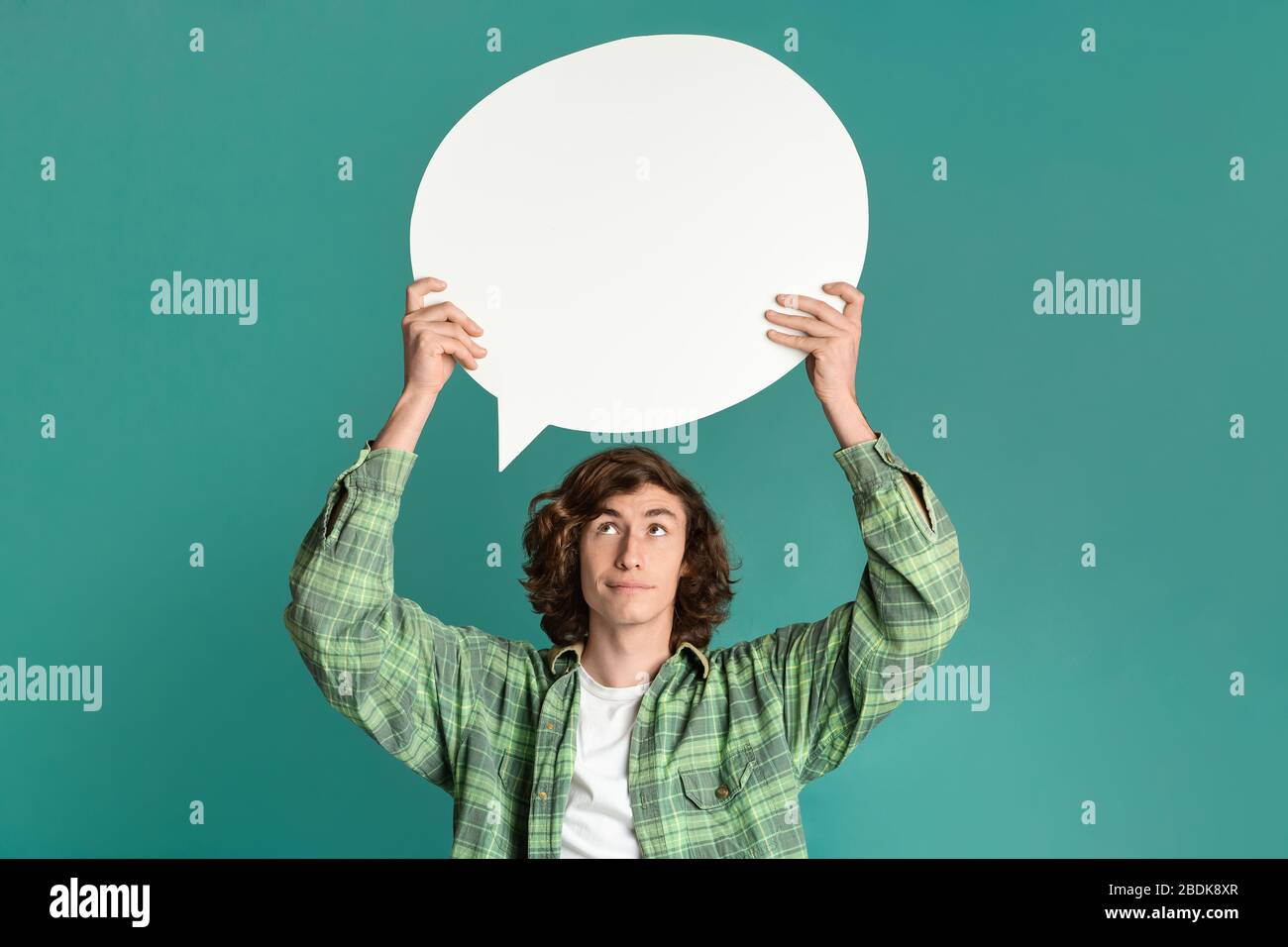 Attractive teenage guy holding speech bubble with blank space for your ...