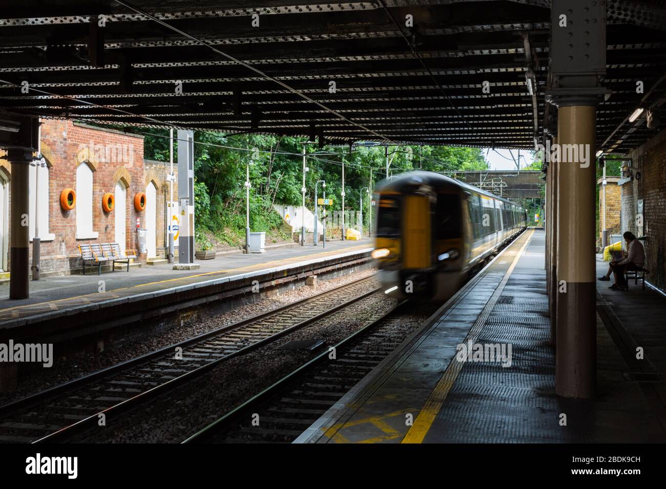 Passengers wait for their overground train at Clapton Railway station ...