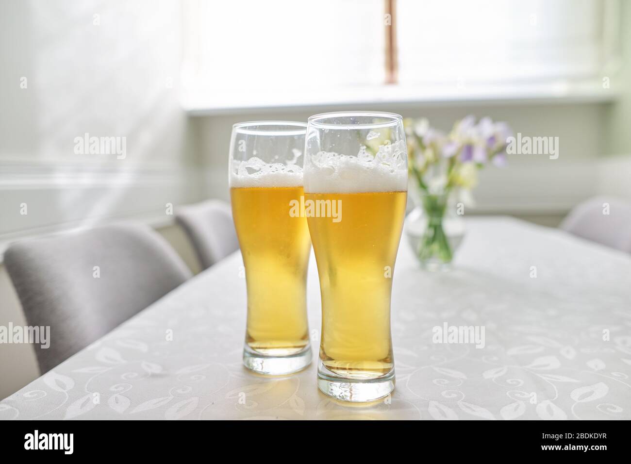 Two glasses of beer on table, home table with chairs near window Stock ...