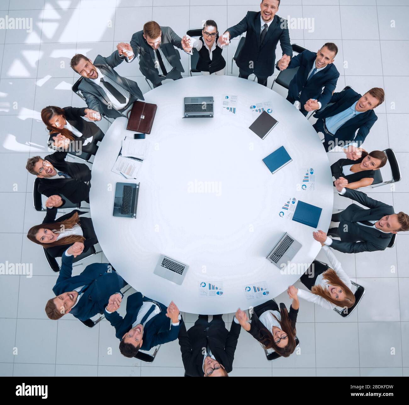large business team sitting at the round table and raising his hands up ...