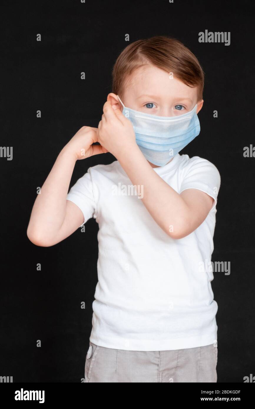 A little boy is holding a medical mask. Baby wears face masks covid-19 ...