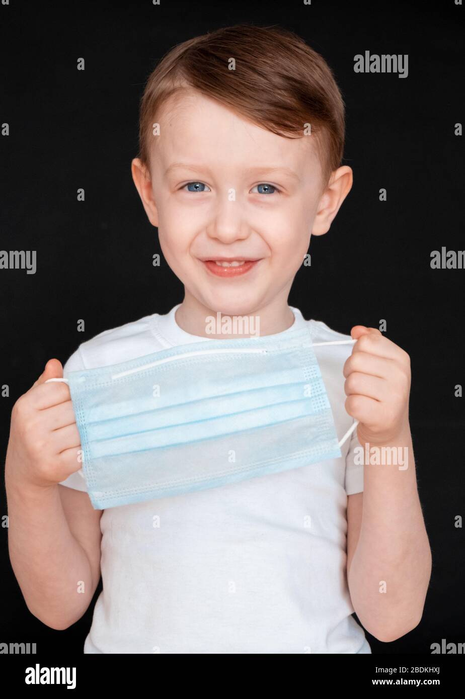A little boy is holding a medical mask. Baby wears face masks covid-19 ...