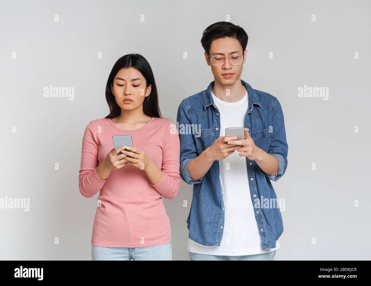 Asian couple using mobile phones during isolation Stock Photo - Alamy