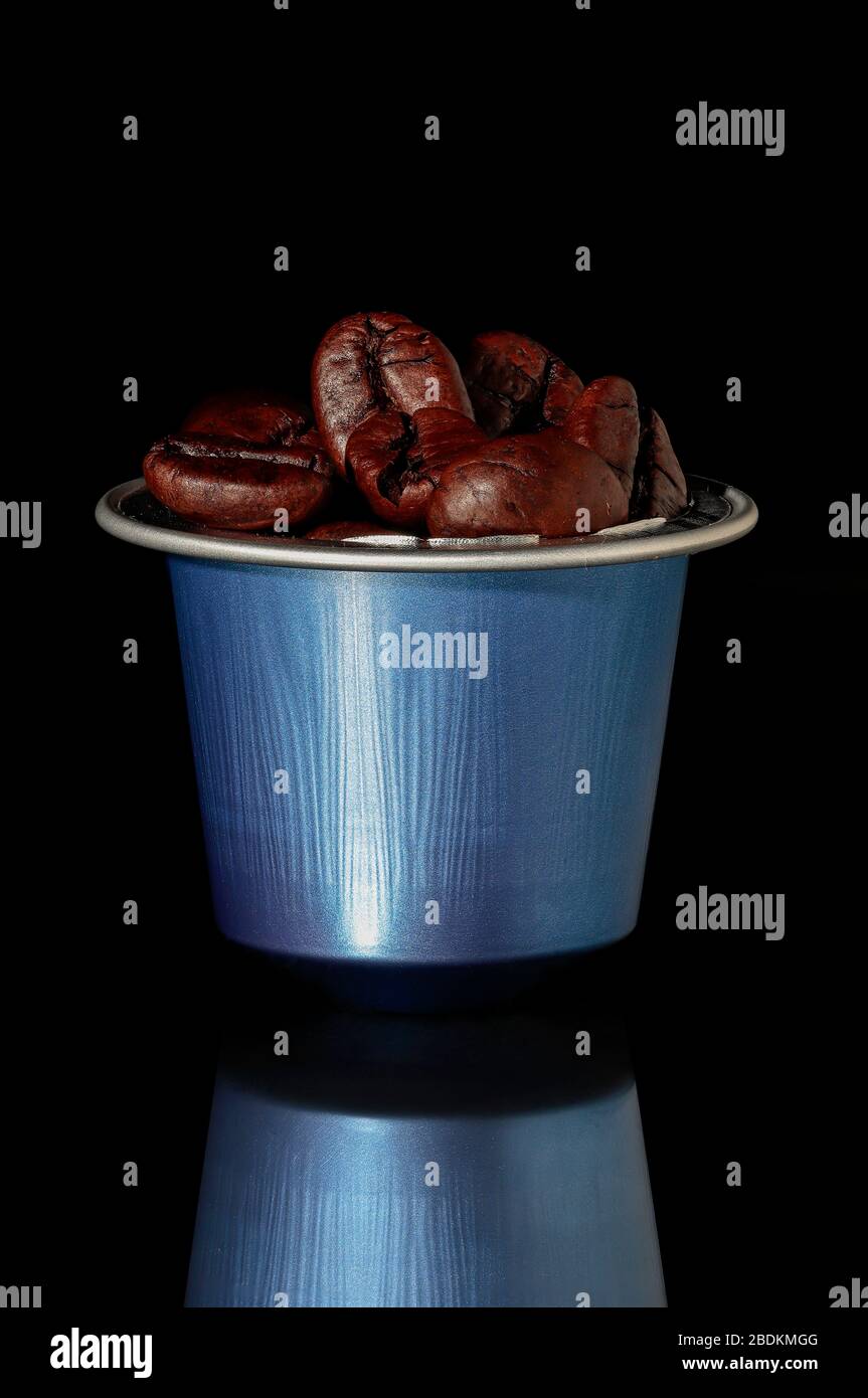blue color coffee capsule with roasted coffee beans and their ...