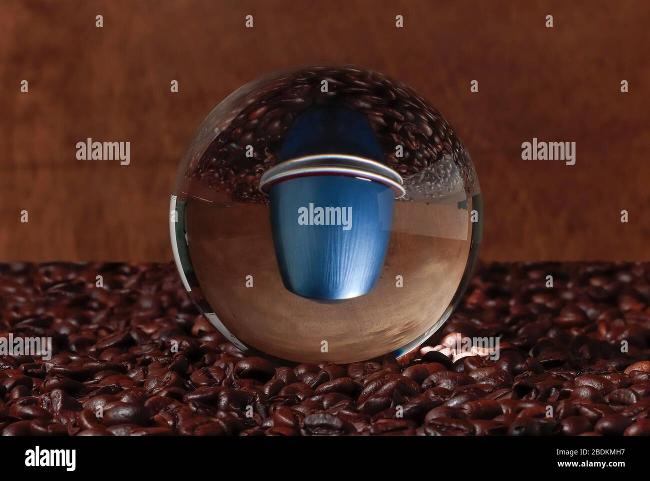 two blue color espresso coffee capsule behind a glass ball over coffee ...