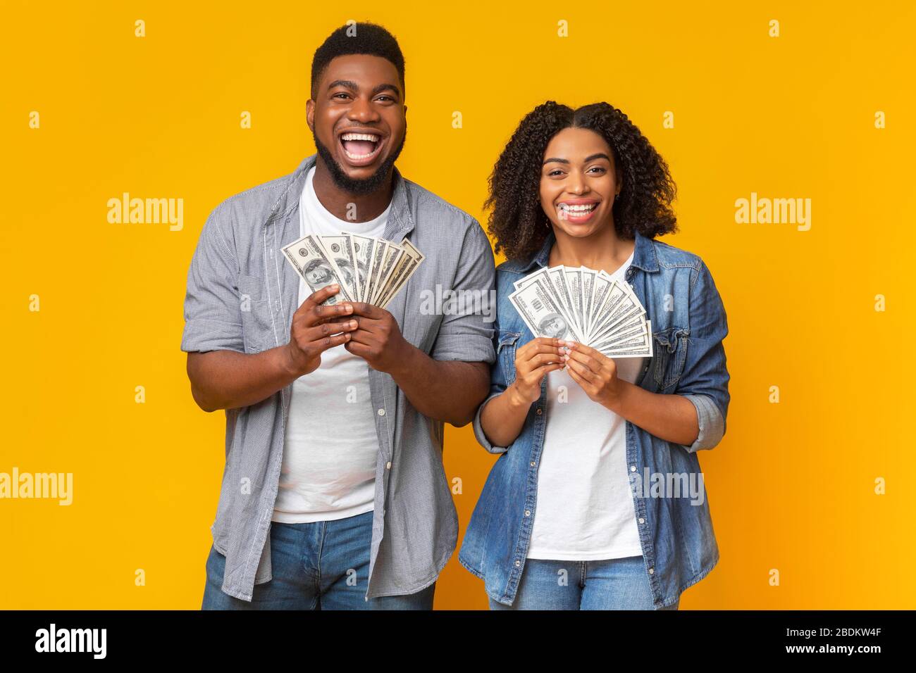 Happy millennial couple posing with lot of money, holding with dollar ...