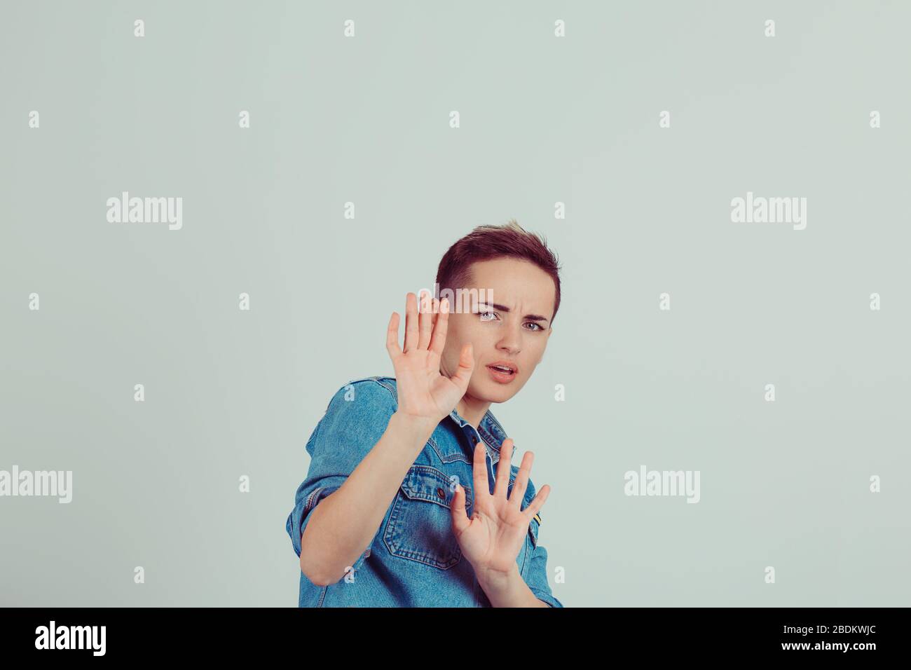 scared woman raising hands up in defense afraid about to be attacked or ...
