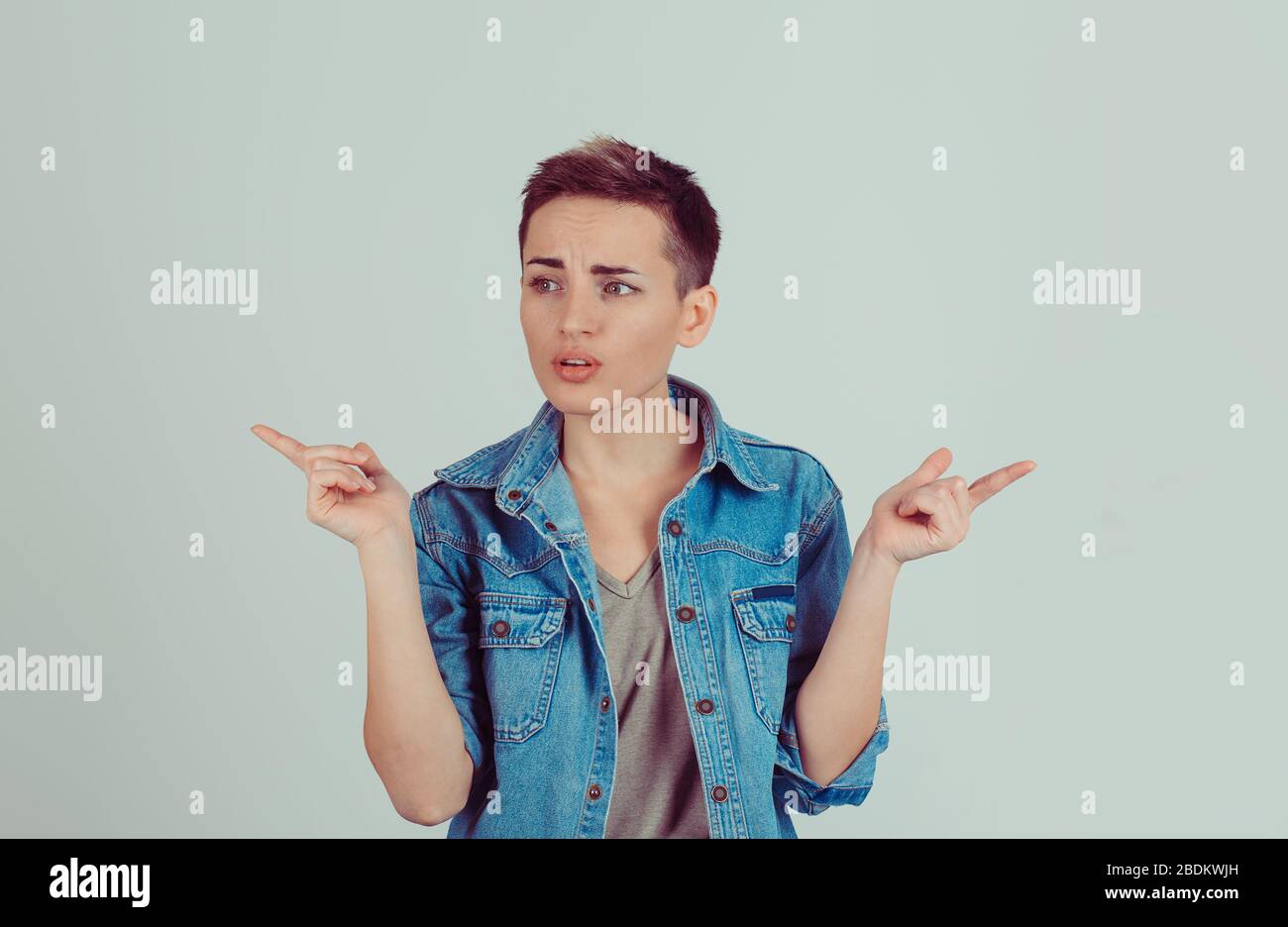 What to do, where to go? Confused brunette girl business woman pointing ...
