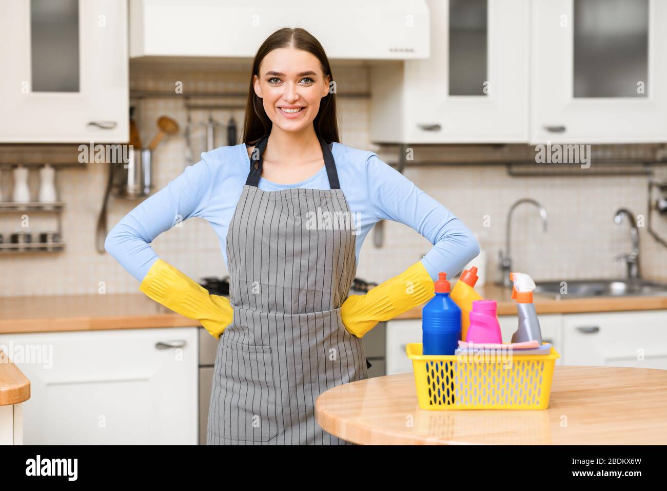 Smiling woman standing in kitchen with detegents Stock Photo - Alamy