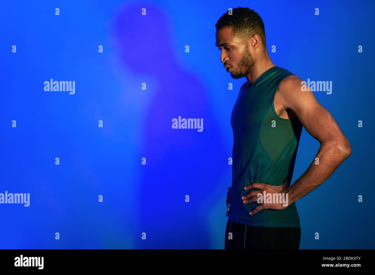 Man In Sportswear Doing Breathing Exercise Standing On Blue Background ...